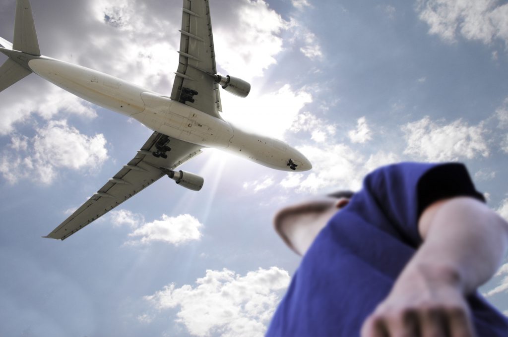 A man looks a airplane passing above him - École d'aviation Rouyn-Noranda